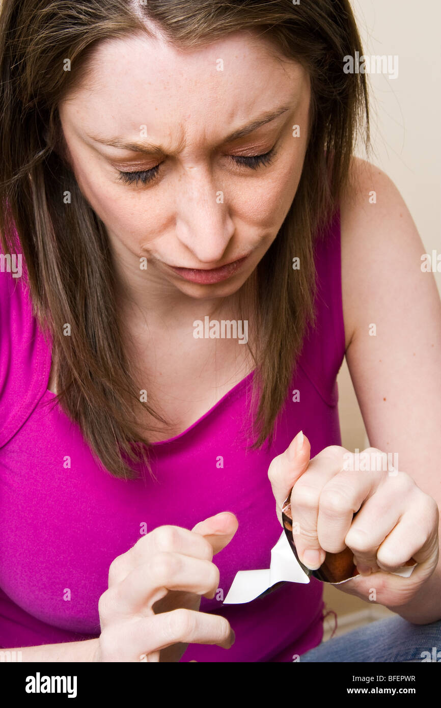 Angry and upset young woman tearing up photos of boyfriend or partner ...