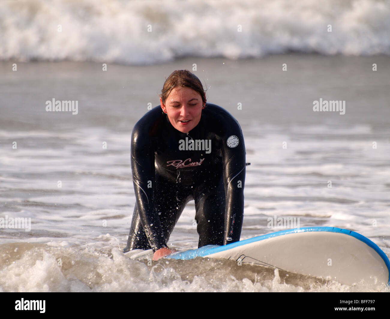 Young woman falling off surf board whilst learning to surf Stock Photo ...