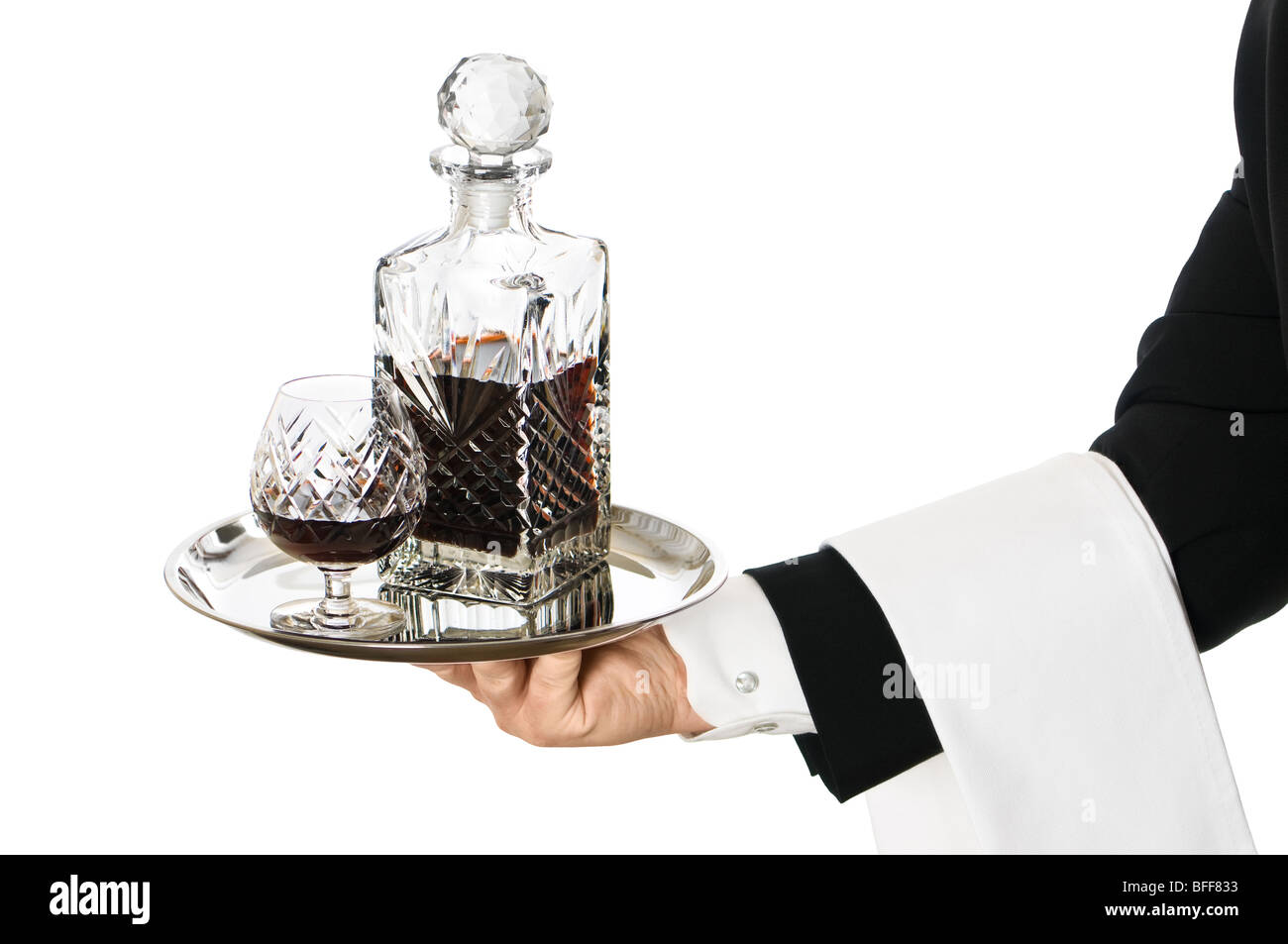 Waiter serving a glass of rum with decanter on silver tray Stock Photo ...