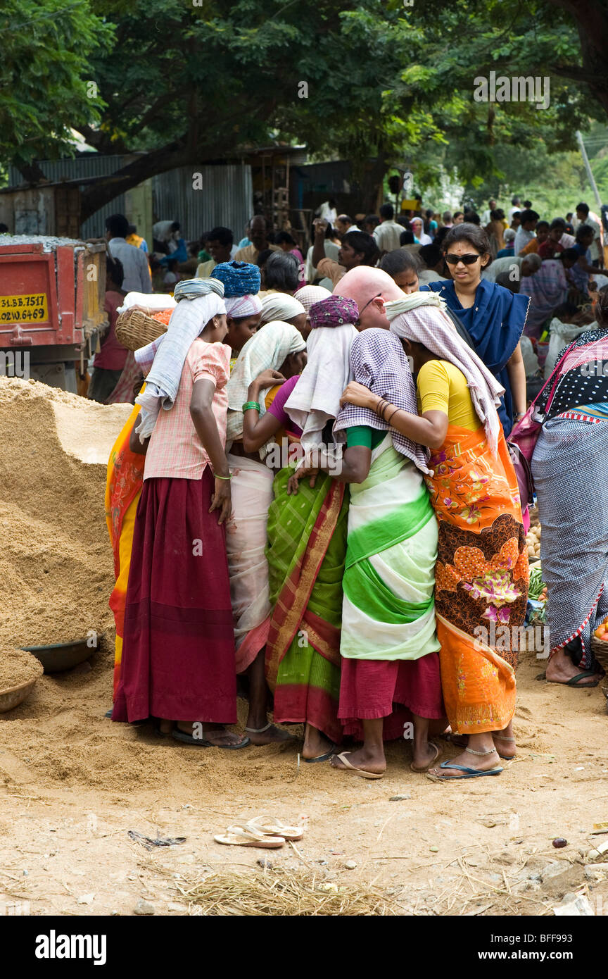Western tourist showing Indian female road workers a digital photo ...