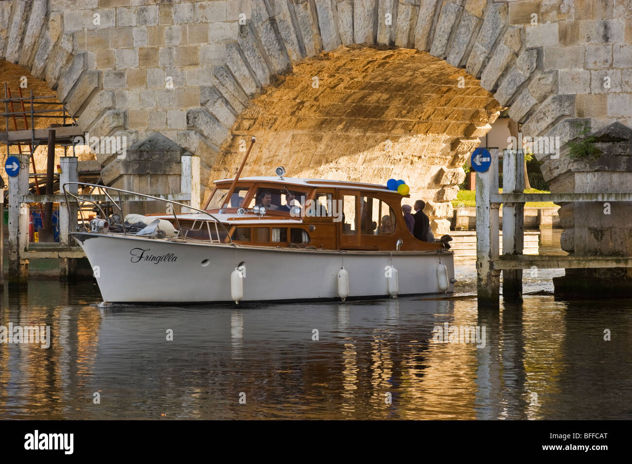 A boat moves under an arch of Maidenhead Bridge over the River Thames ...