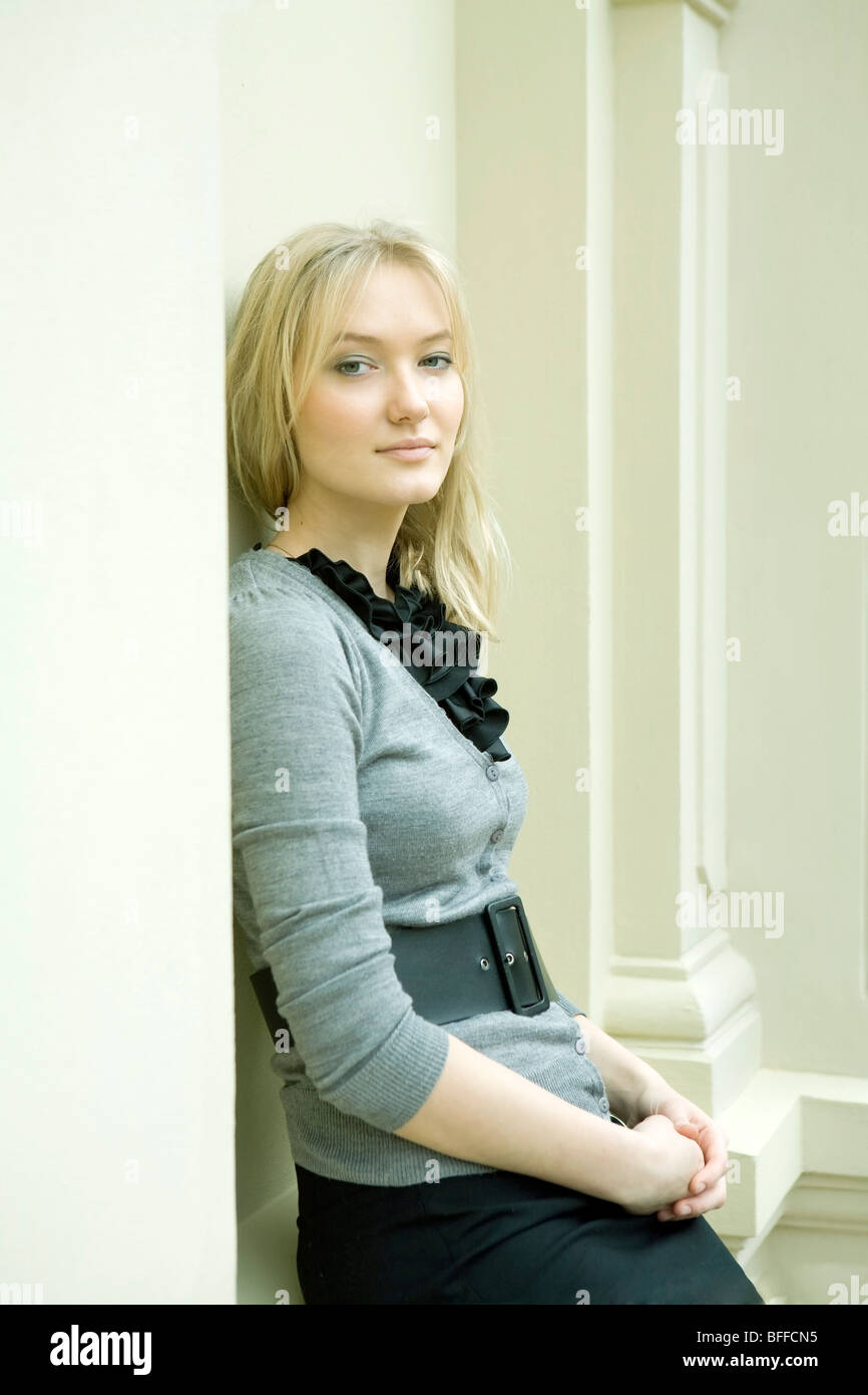 blond woman tired form shopping rest against wall Stock Photo - Alamy