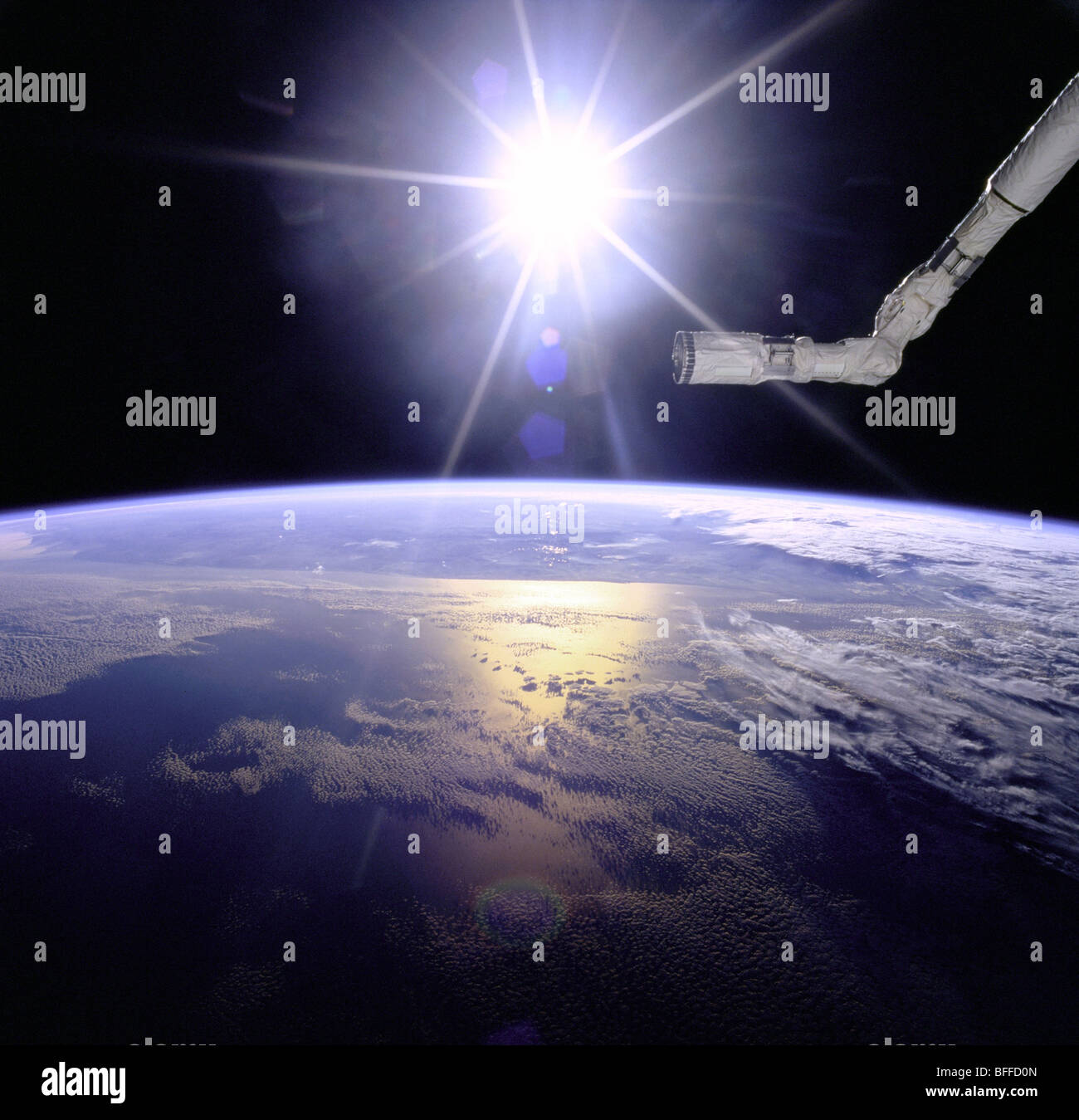 Robot arm extended from NASA shuttle vehicle and sun burst Stock Photo ...