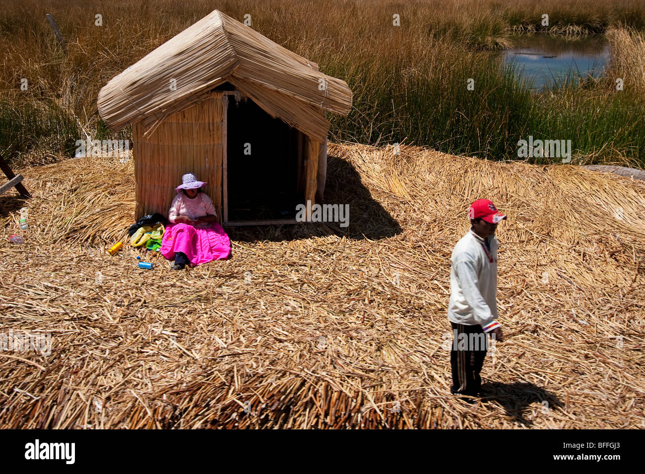 Native inhabitants of Uros and a typical hut made of reed on one of the ...