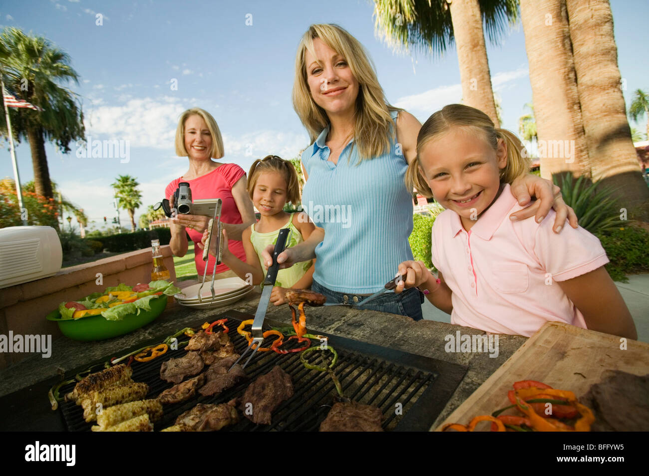 Two girls (7-9) with family at outdoor barbecue, portrait Stock Photo ...