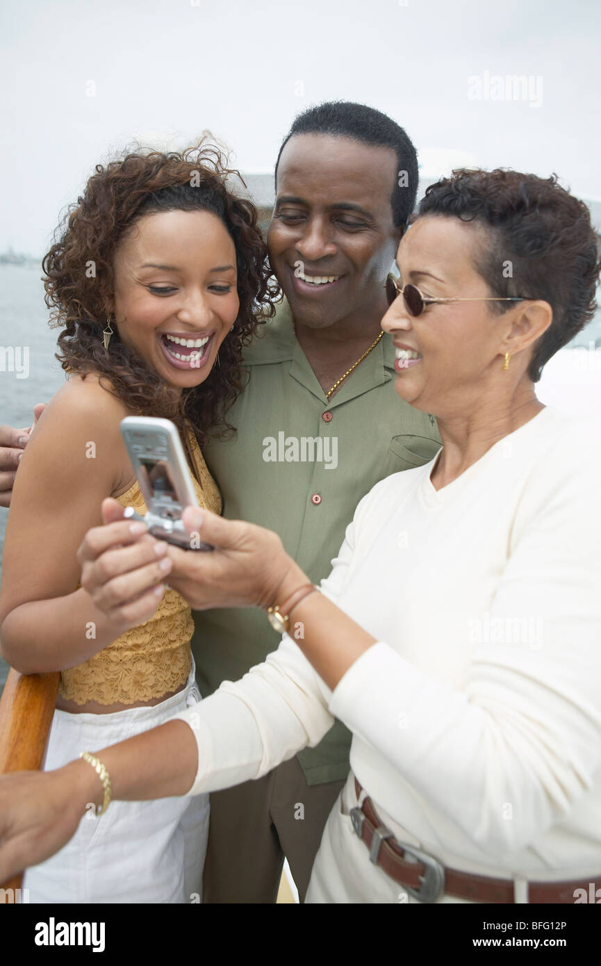 Three Friends Using Cell Phone on Yacht Stock Photo - Alamy