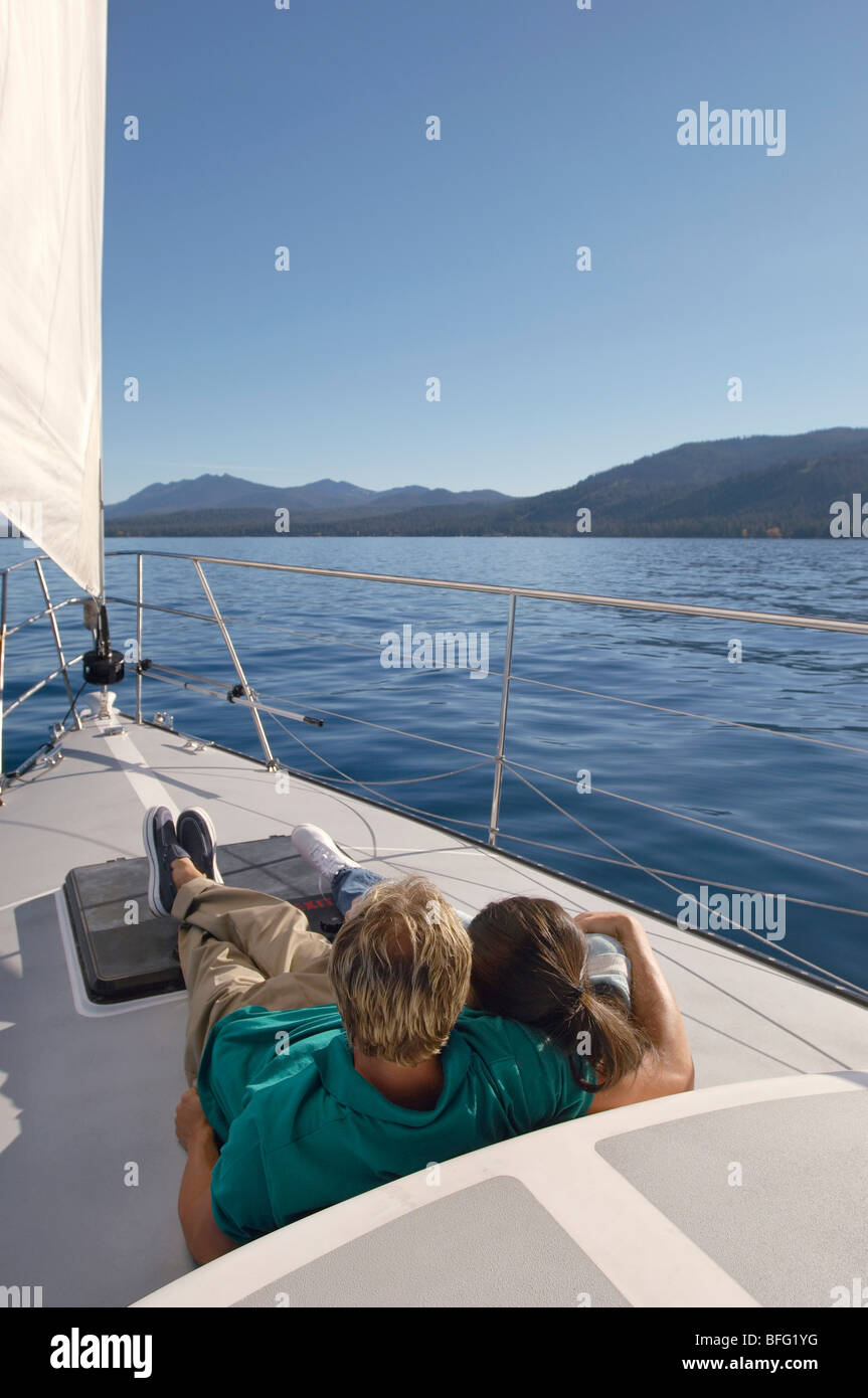 Young couple sitting on sailboat, rear view, (elevated view Stock Photo ...