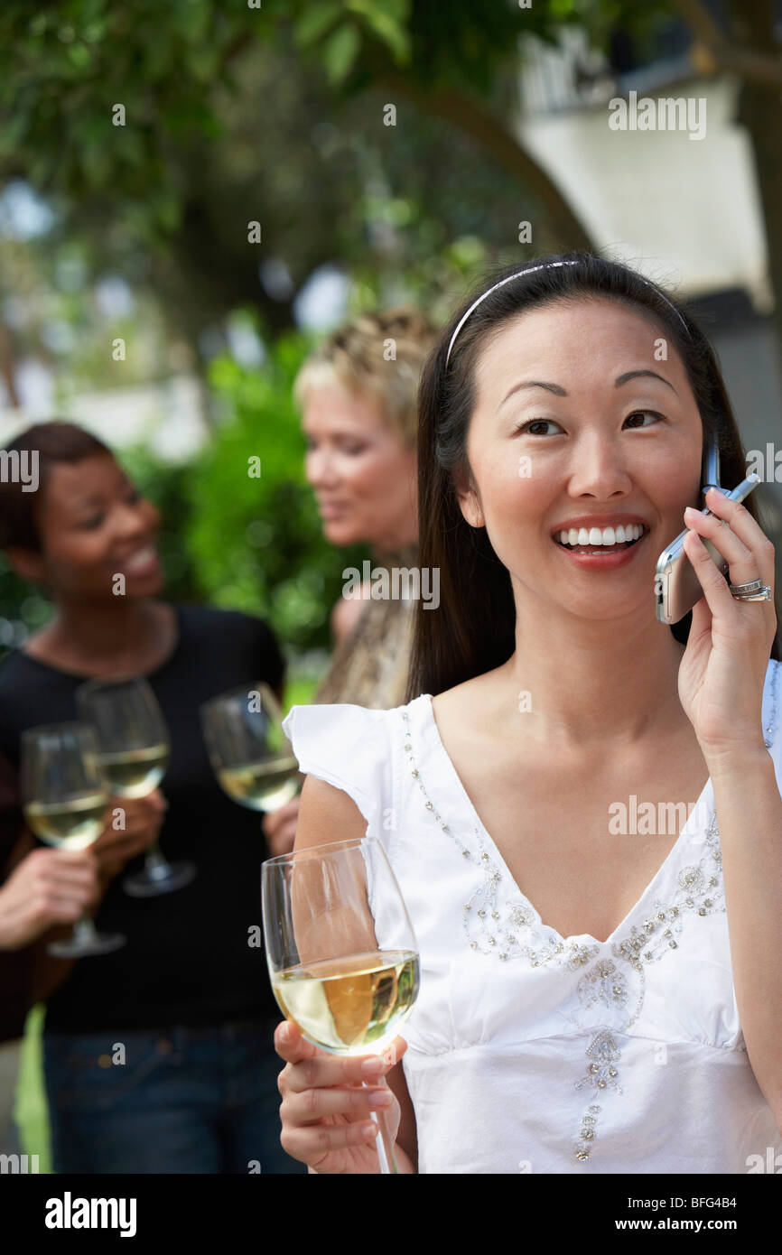 Woman using cell phone at garden party Stock Photo - Alamy