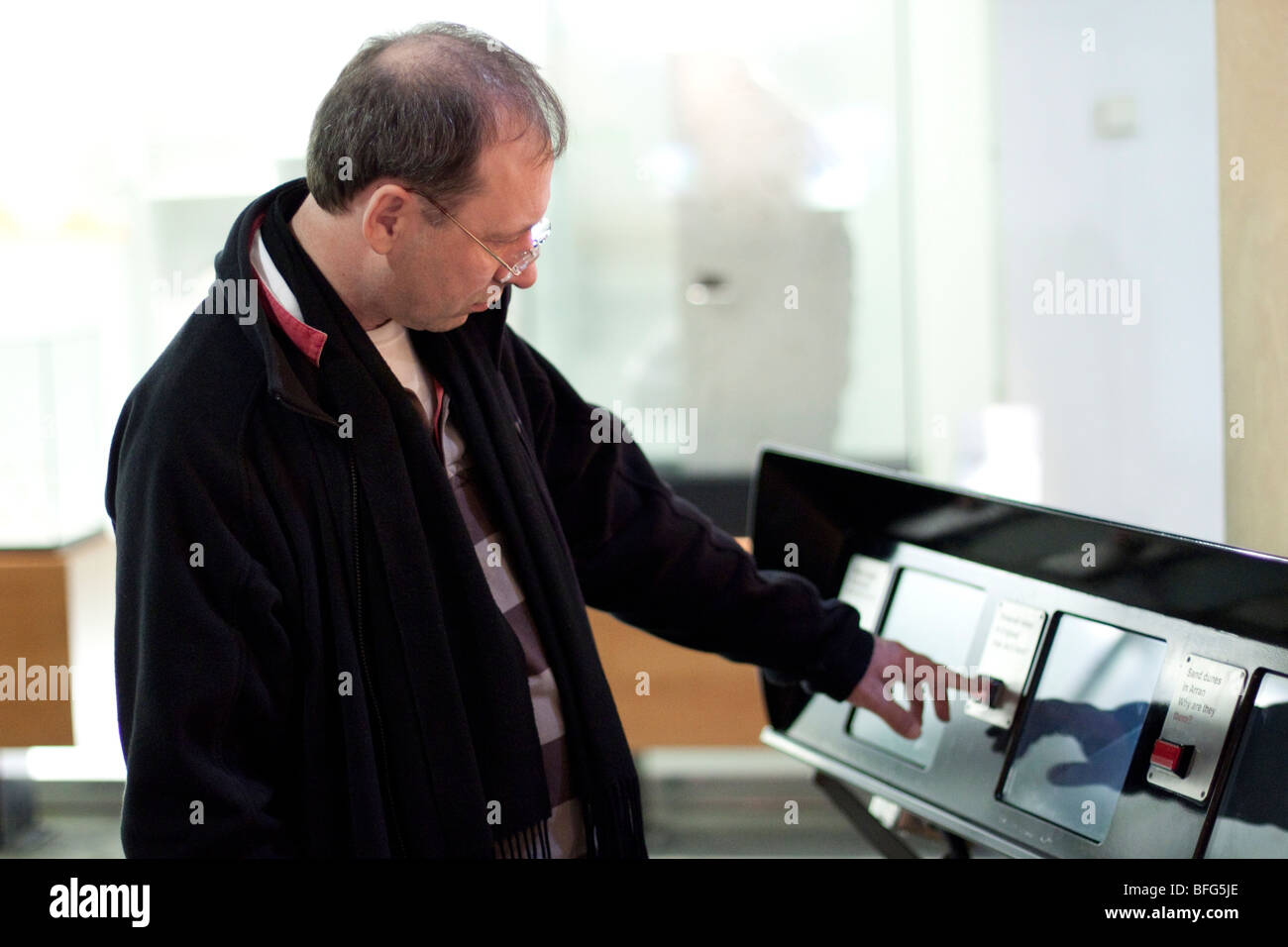 Man using a push button hands on exhibit at the Natural History Museum ...