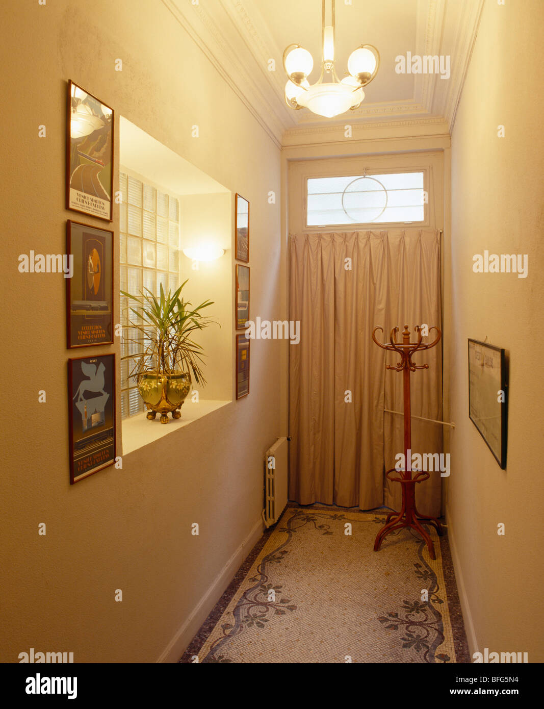 Mosaic tiled floor and recessed glass brick window in narrow hall with ...