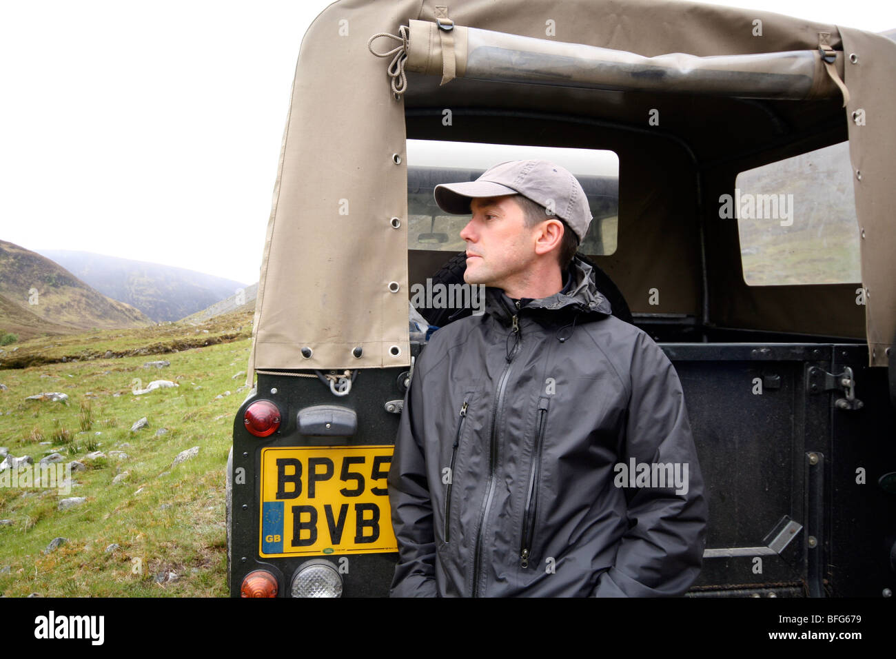 Man standing behind a land rover in Scotland Stock Photo - Alamy