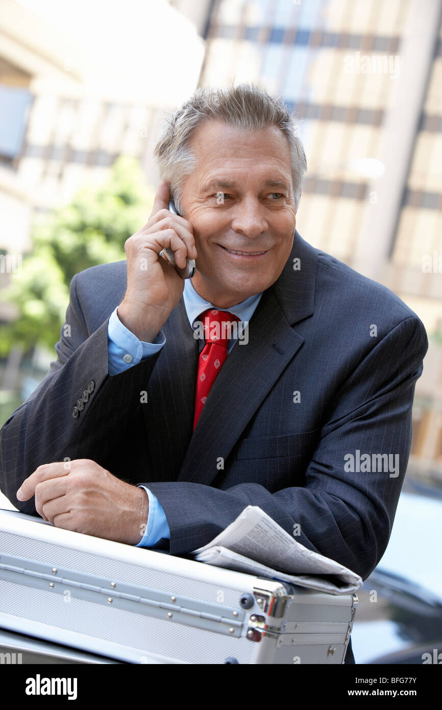 Businessman using cell phone outdoors, half length Stock Photo - Alamy