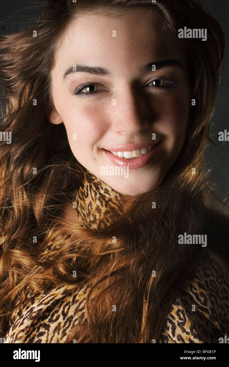 A beautiful young brunette woman smiling and wearing a leopard print ...