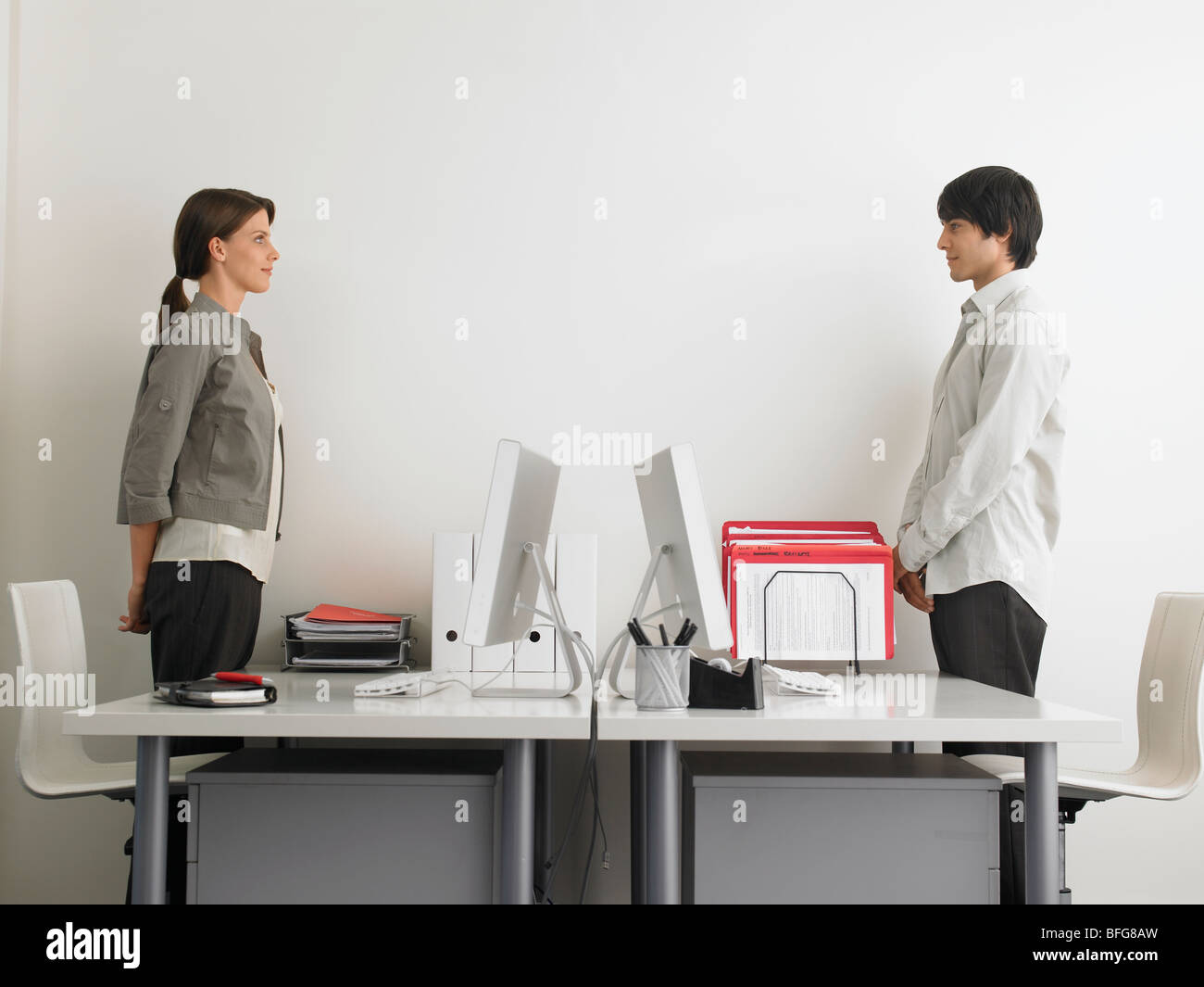 Two Office Workers Standing Facing Each Other Stock Photo - Alamy