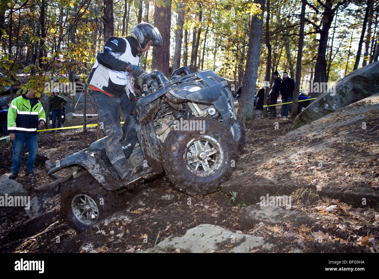 Man rides all-terrain vehicle (ATV) on steep uphill terrain in woods ...