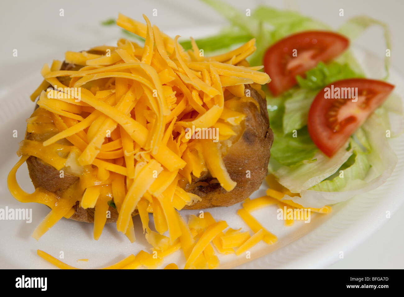 Jacket Potato with cheese filling and a salad garnish Stock Photo - Alamy