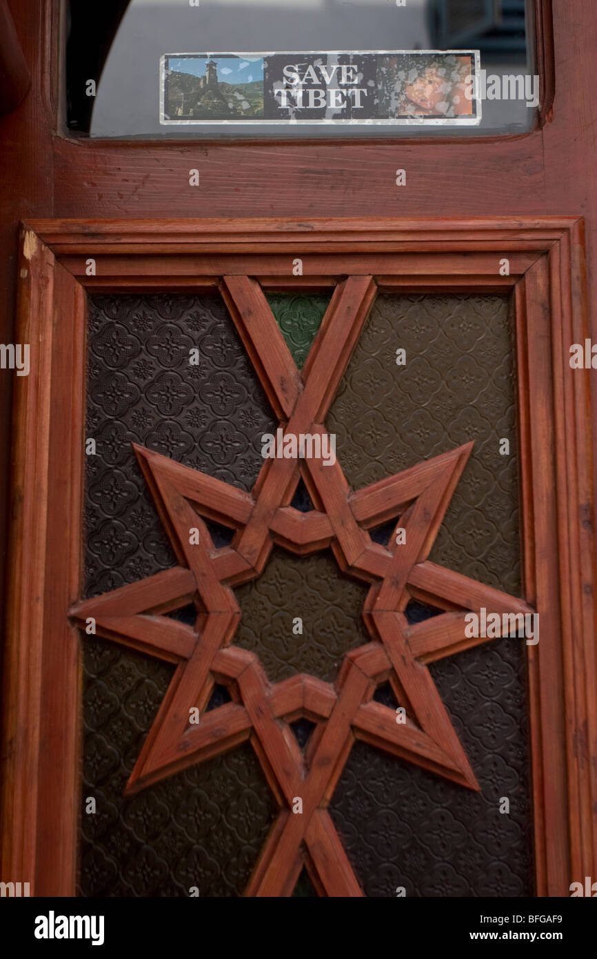 A door features a carved star and a Free Tibet sticker, in Essaouira ...