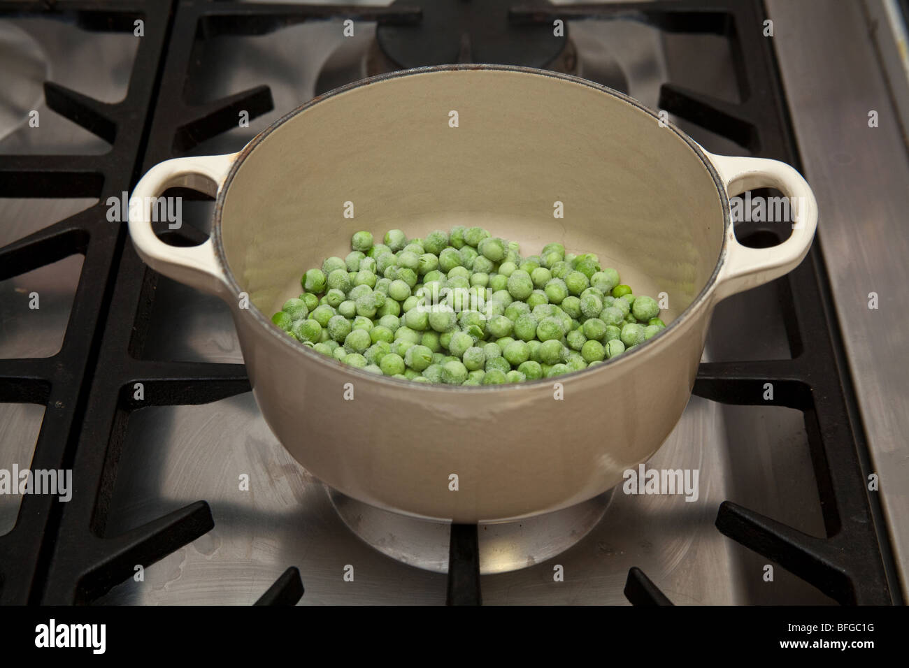 Garden peas cooking on a gas stove Stock Photo - Alamy