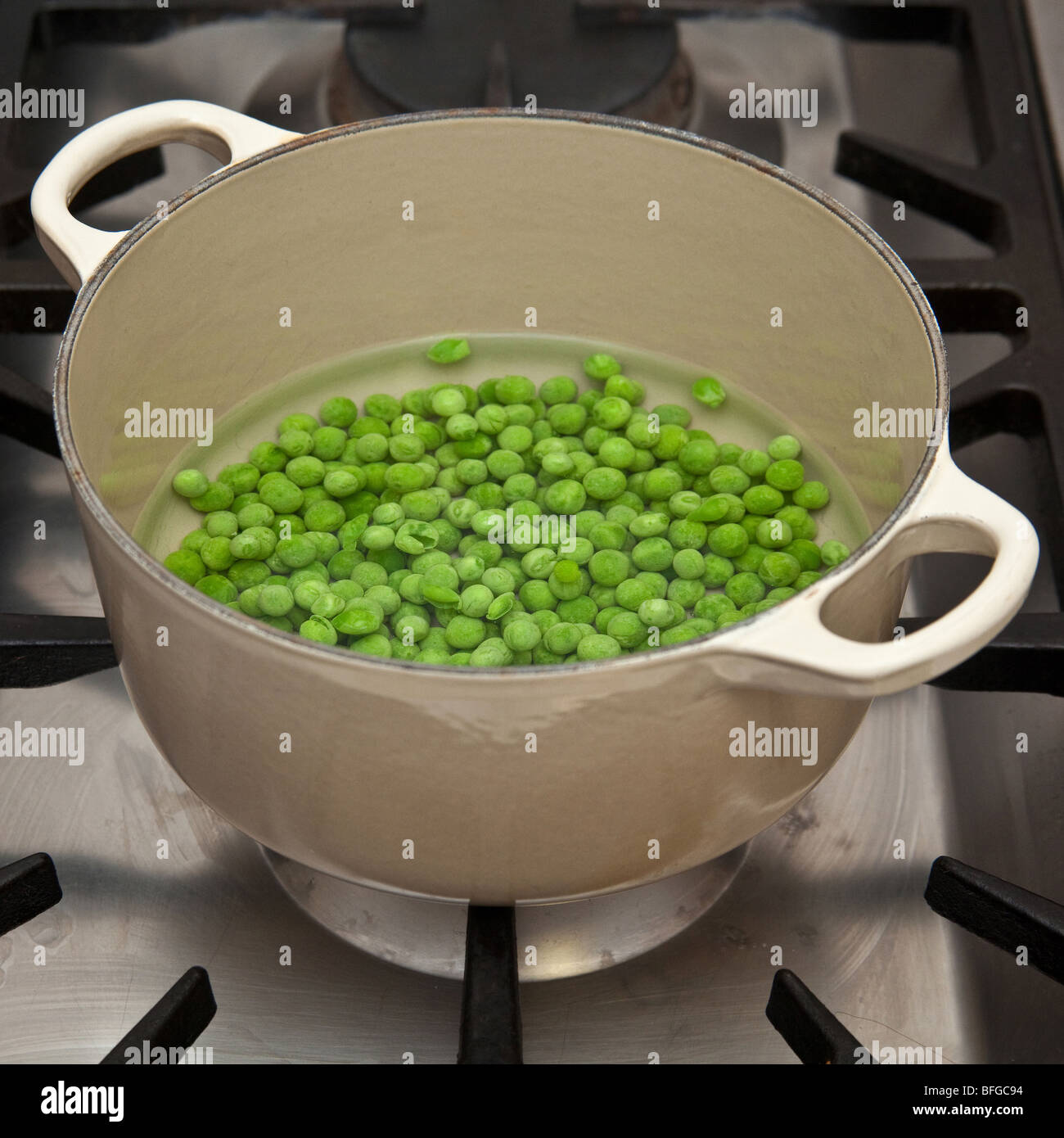Garden peas cooking on a gas stove Stock Photo - Alamy