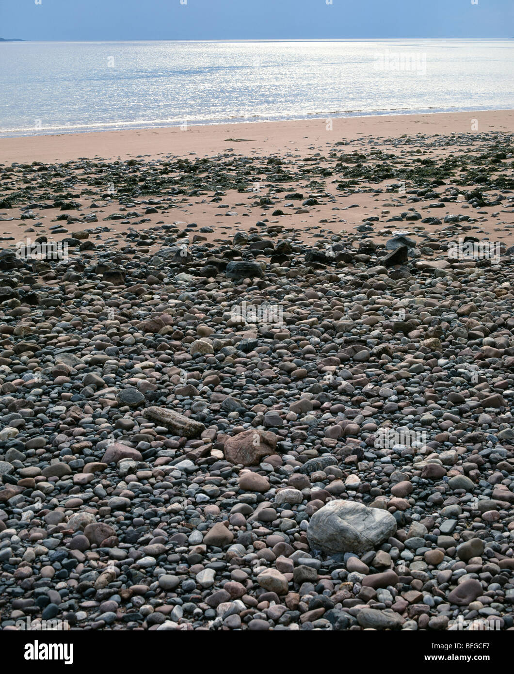 A pebble beach and thin strip of sky above the horizon in Gairloch ...