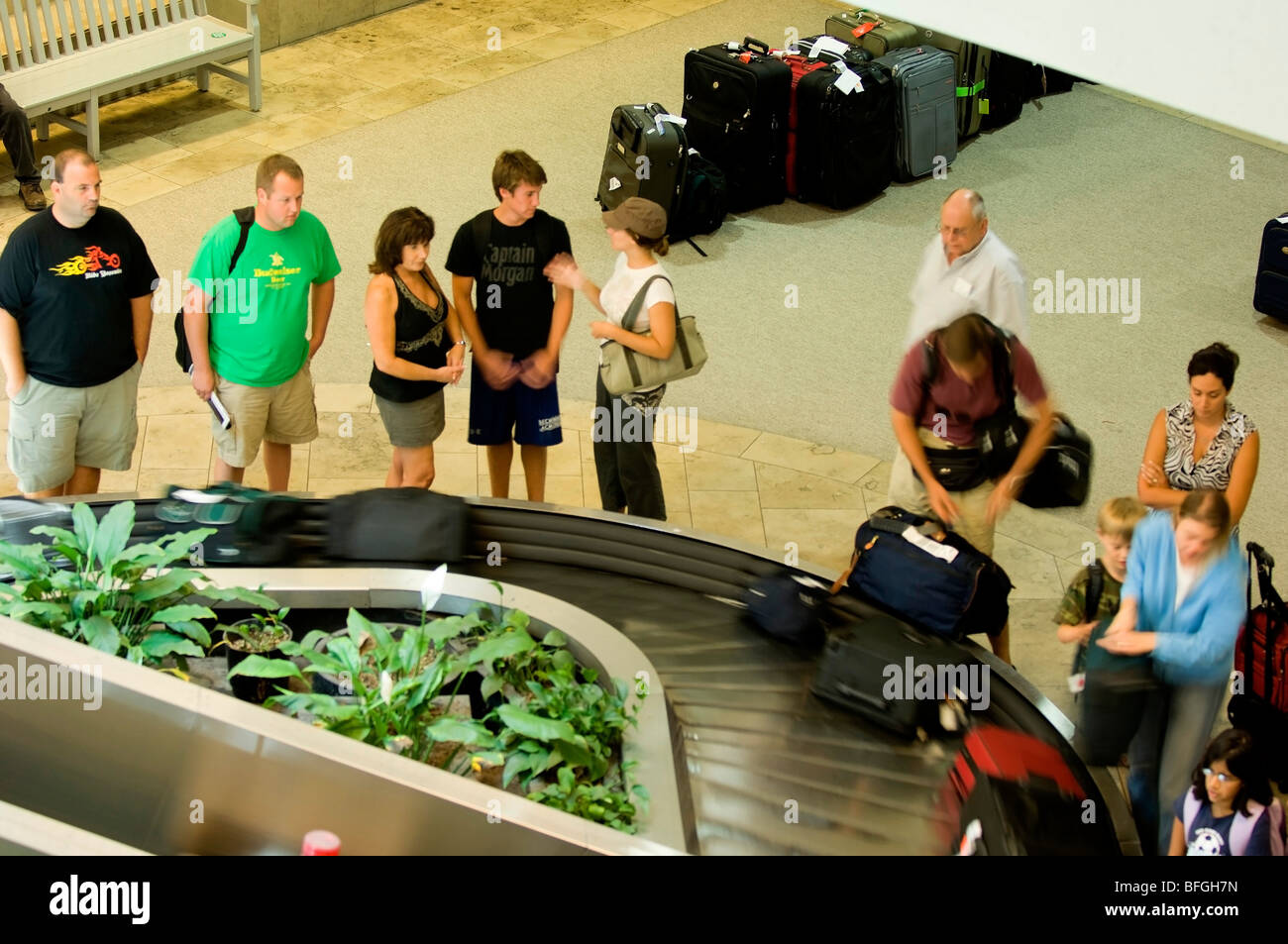 Passengers wait for their bags at the baggage carousel Stock Photo - Alamy