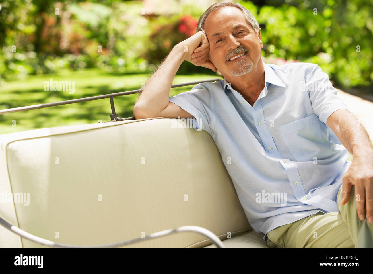 Man Relaxing in back yard on sofa, portrait Stock Photo - Alamy