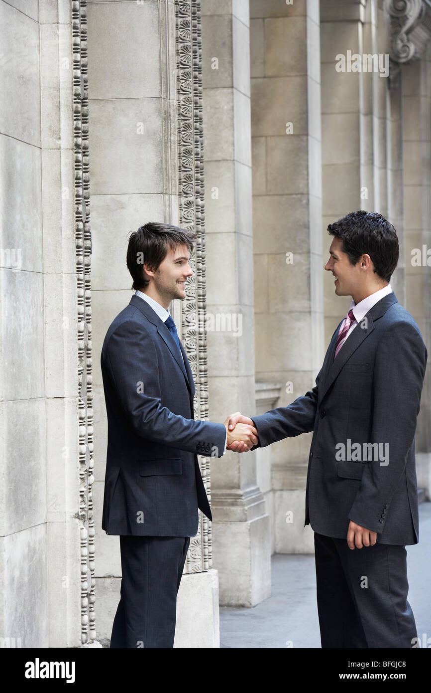 Two businessmen shaking hands outside building Stock Photo - Alamy