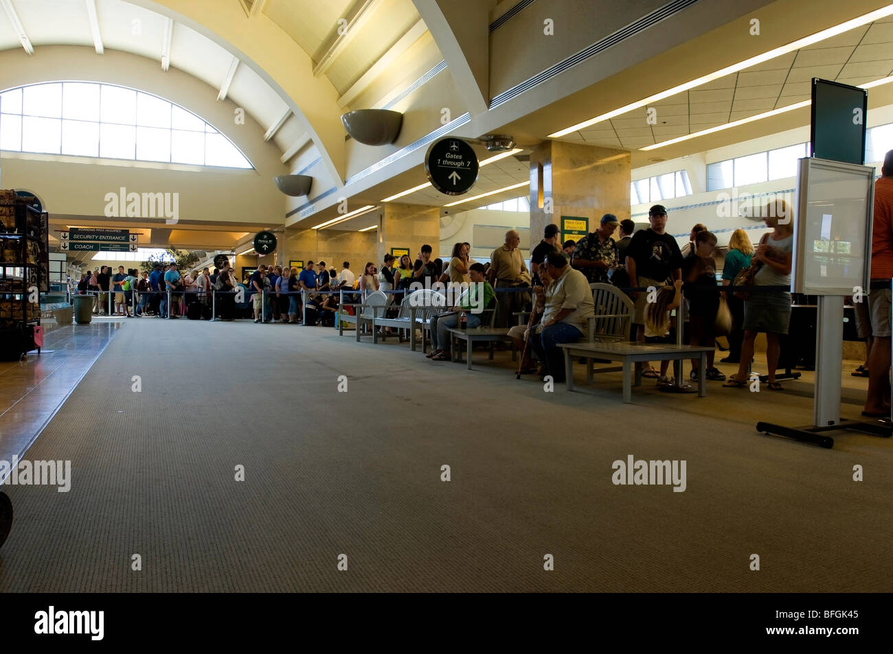 Passengers wait in long lines with their boarding passes in hand before ...