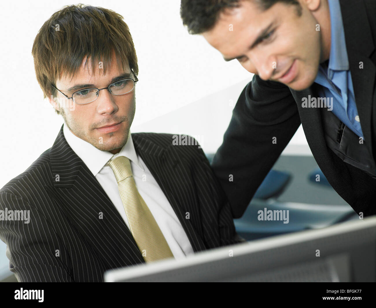 Two businessmen in office looking at computer screen Stock Photo - Alamy