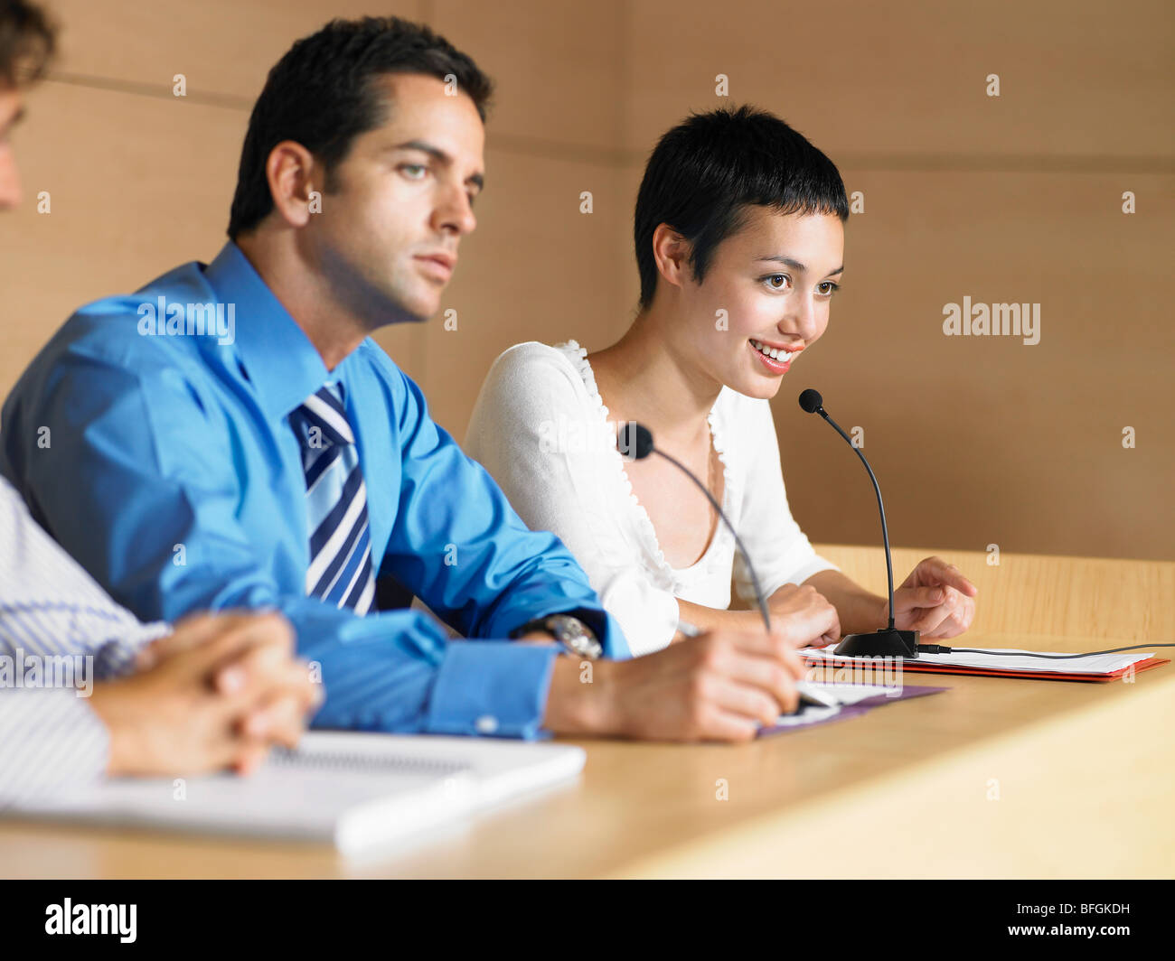 Three businesspeople at Panel Presentation Stock Photo - Alamy
