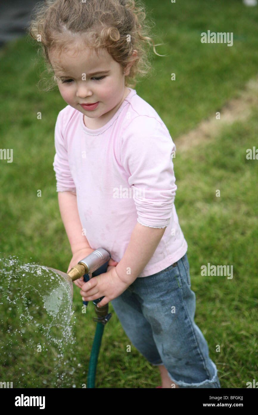 Toddler girl holding water hose hi-res stock photography and images - Alamy