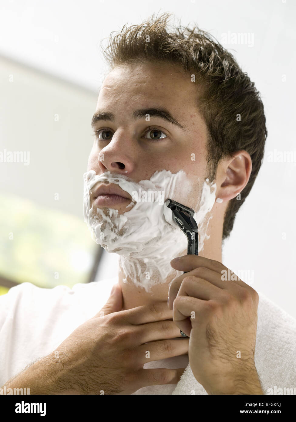 Young Man shaving with a razor Stock Photo - Alamy