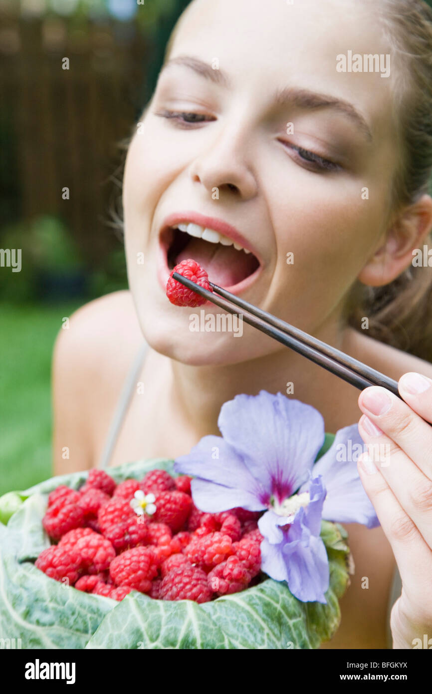 woman eating raspberries in garden Stock Photo - Alamy