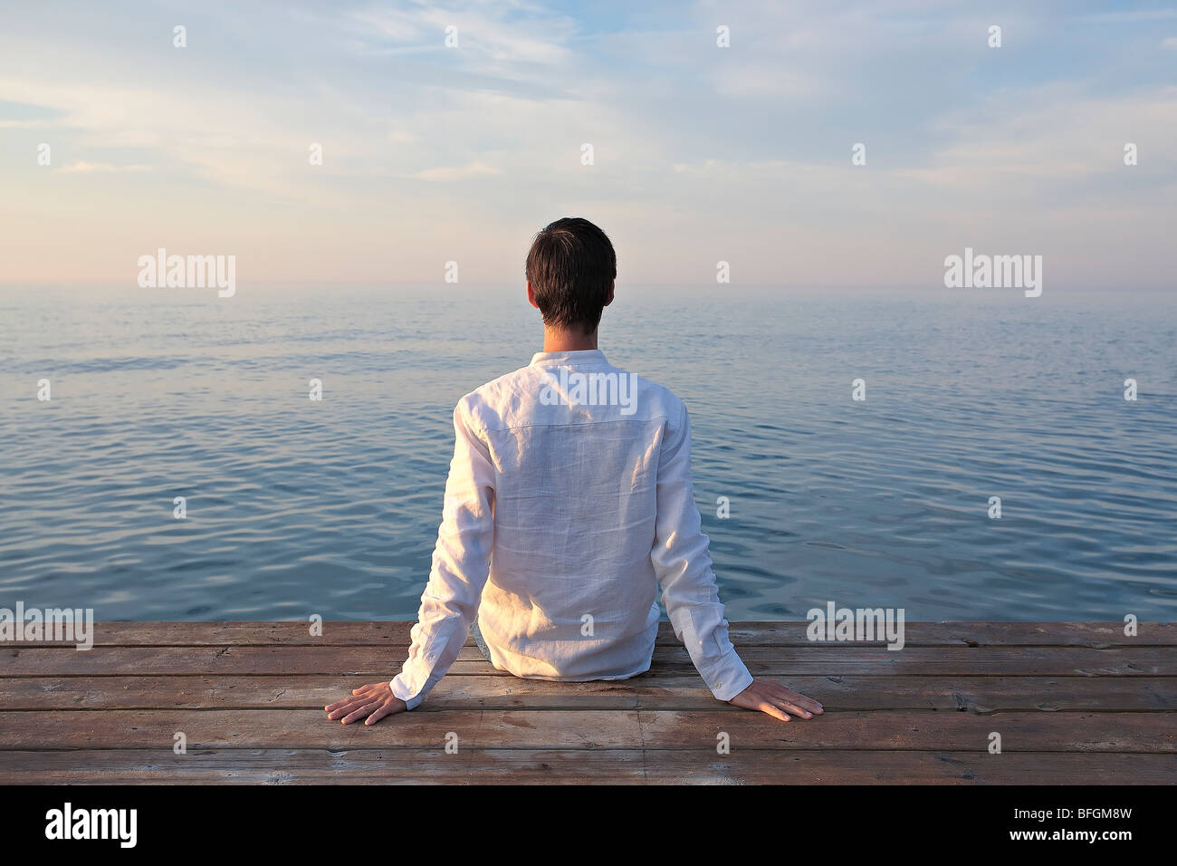 Man sitting on wooden dock at sunrise hi-res stock photography and ...