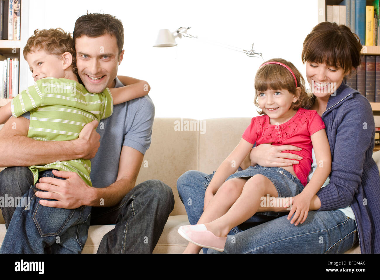 family sitting on sofa Stock Photo - Alamy