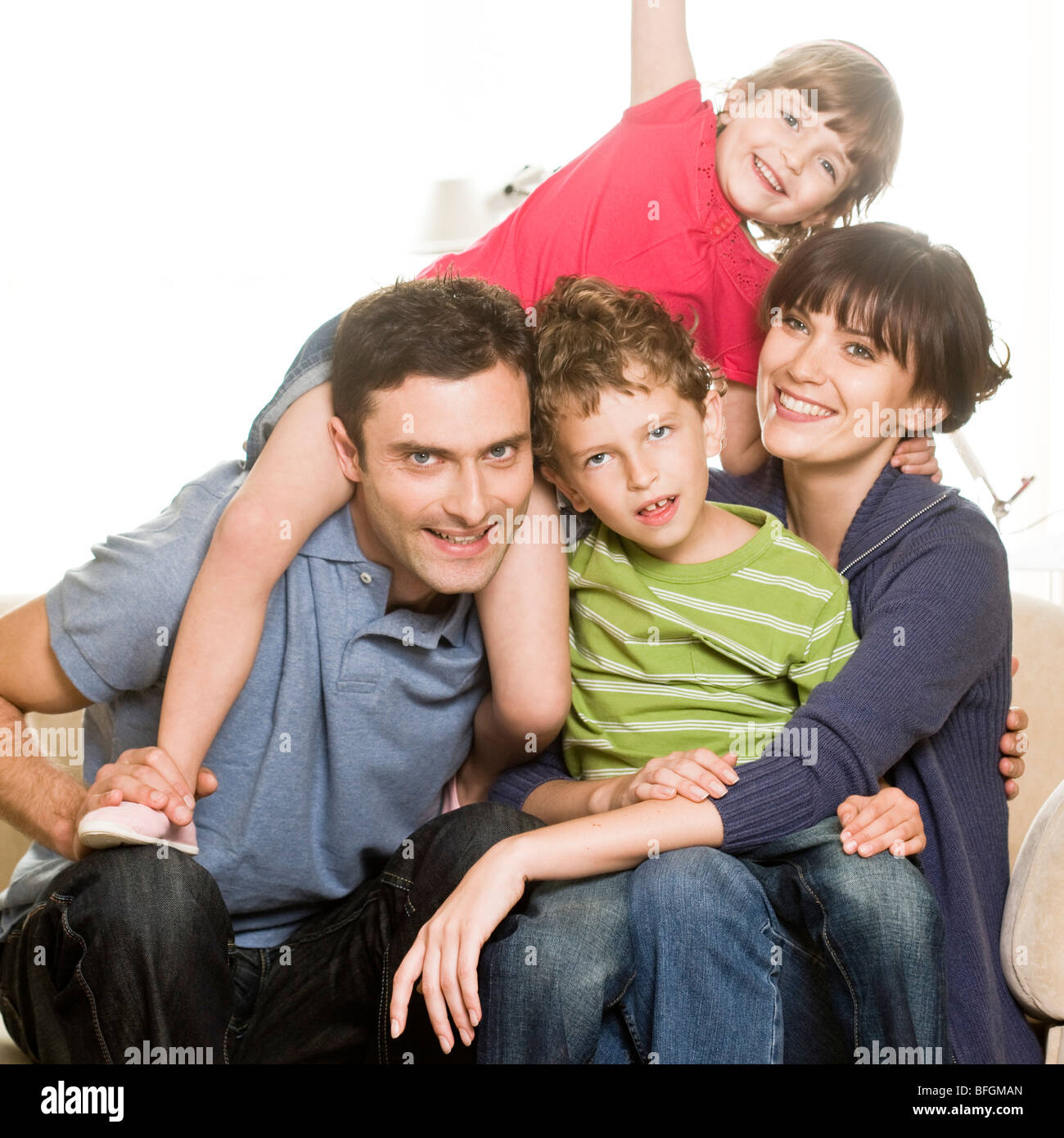 family sitting on sofa Stock Photo - Alamy