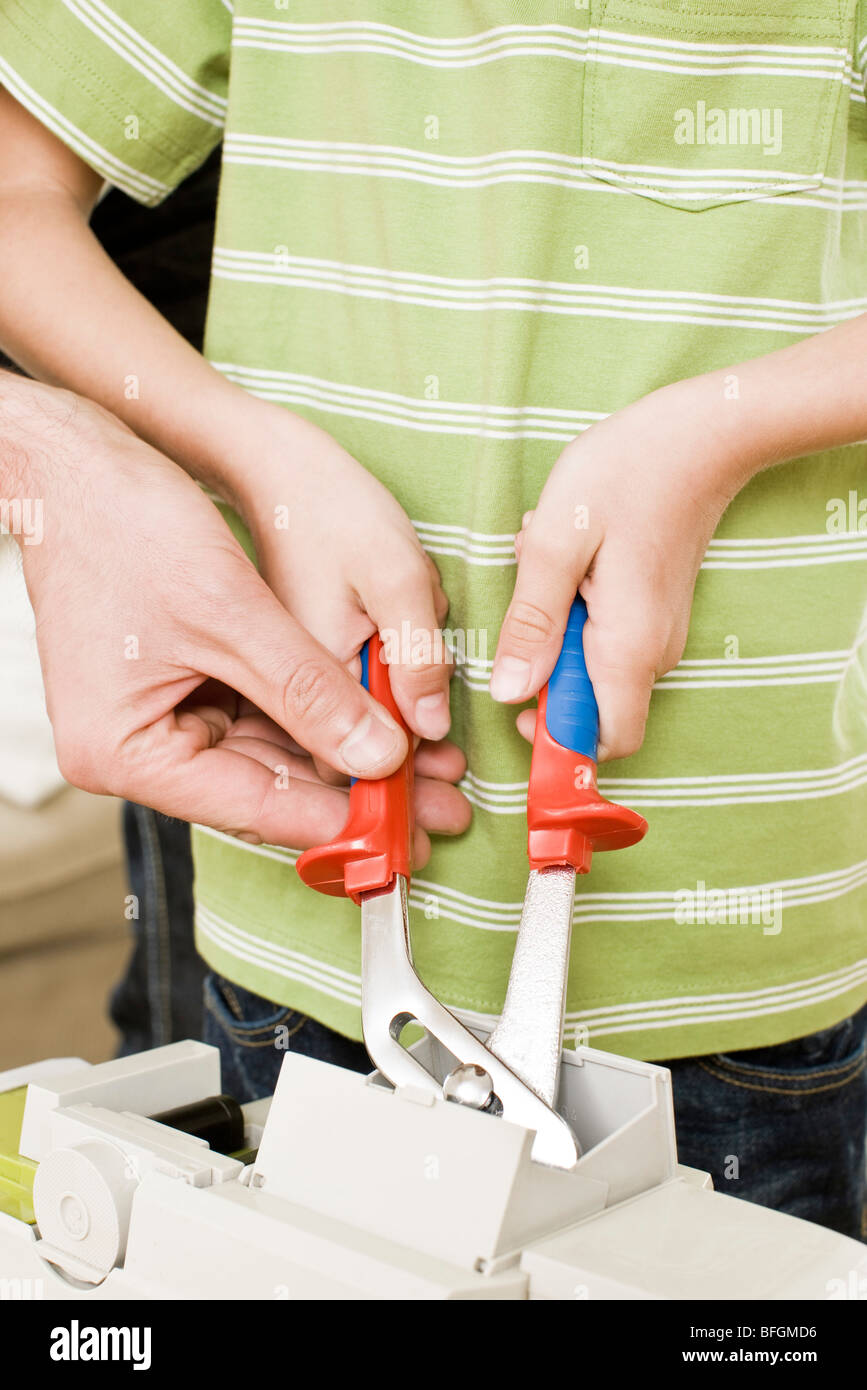 father fixing toy with son Stock Photo - Alamy