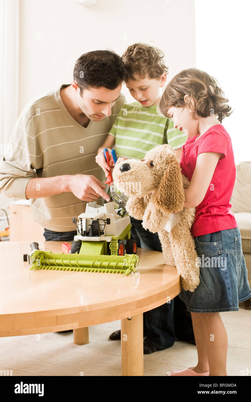 father fixing toy with son Stock Photo - Alamy