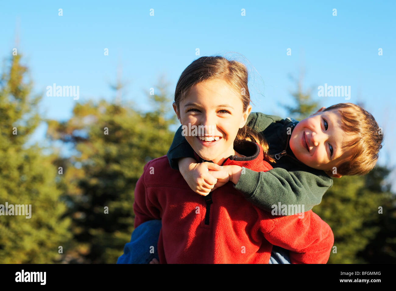 Sister giving younger brother piggyback ride, King City, Ontario Stock ...