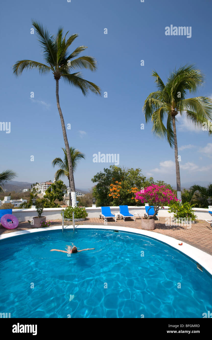 Woman swimming in pool with palm trees, Manzanillo, Jalisco, Mexico ...