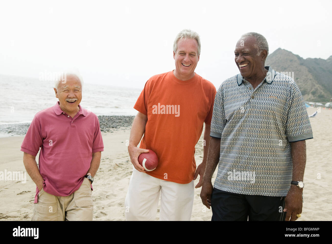 Three senior men walking on beach Stock Photo - Alamy