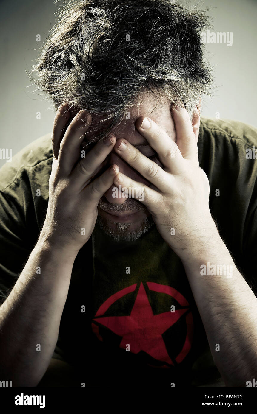 Man with face in his hands Stock Photo - Alamy
