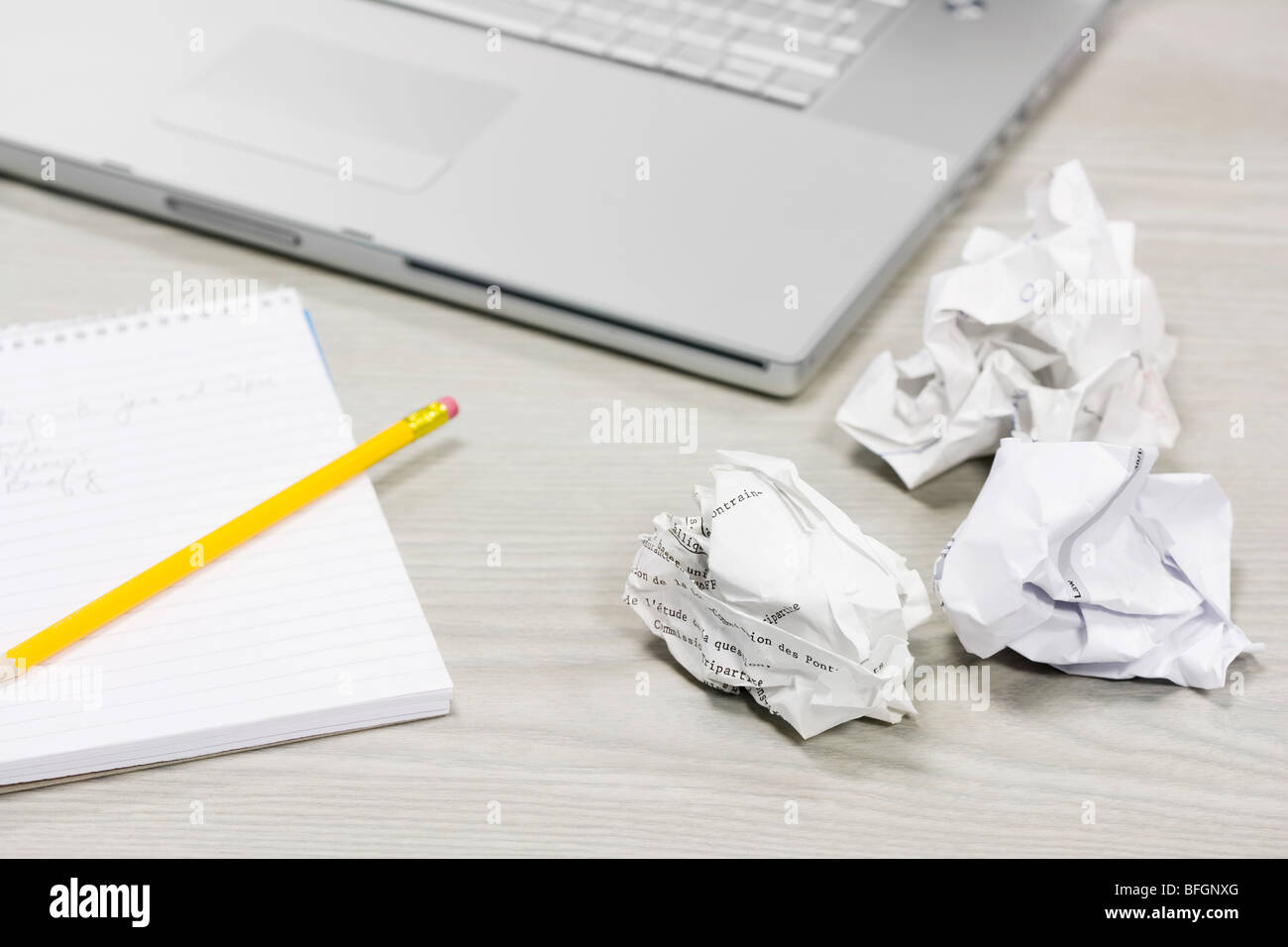 Crumpled paper and notebook on desk by laptop, close up Stock Photo - Alamy