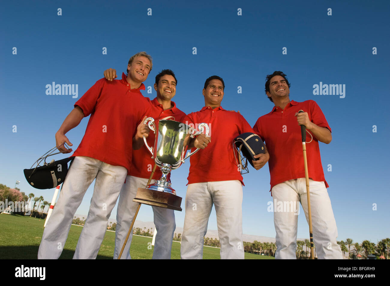 Four polo players with trophy Stock Photo - Alamy