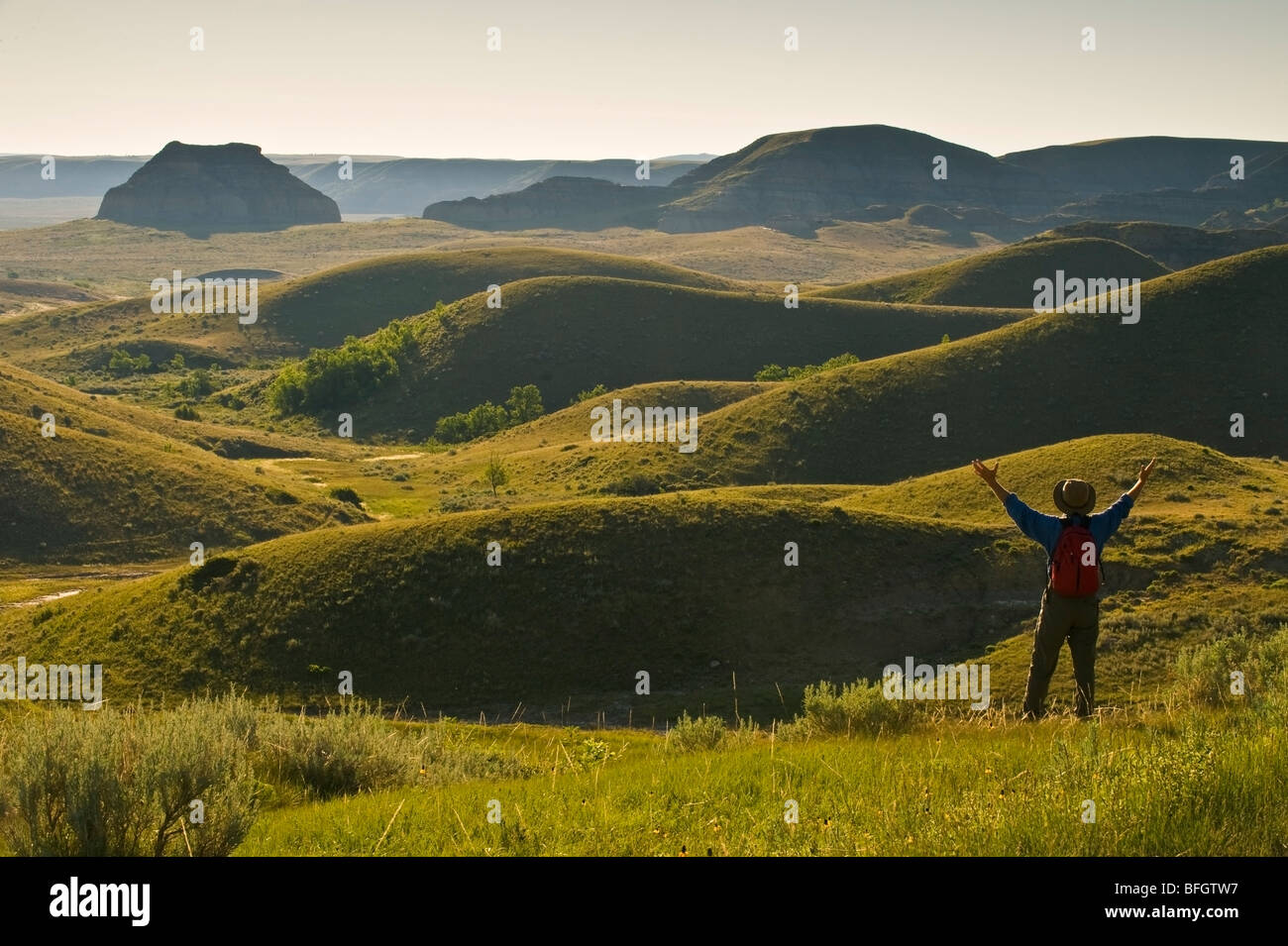A hiker looks out over landscape, Big Muddy Badlands, Saskatchewan ...