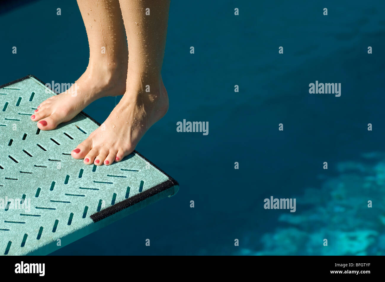 Swimmer standing on diving board at sunset Stock Photo - Alamy