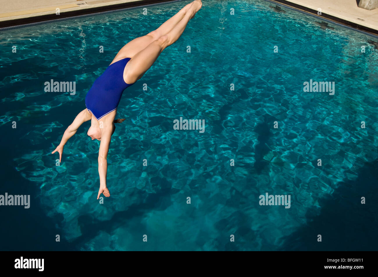 Young woman diving into swimming pool Stock Photo - Alamy