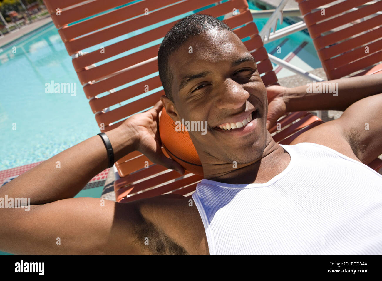 Young man relaxing by swimming pool, portrait Stock Photo - Alamy
