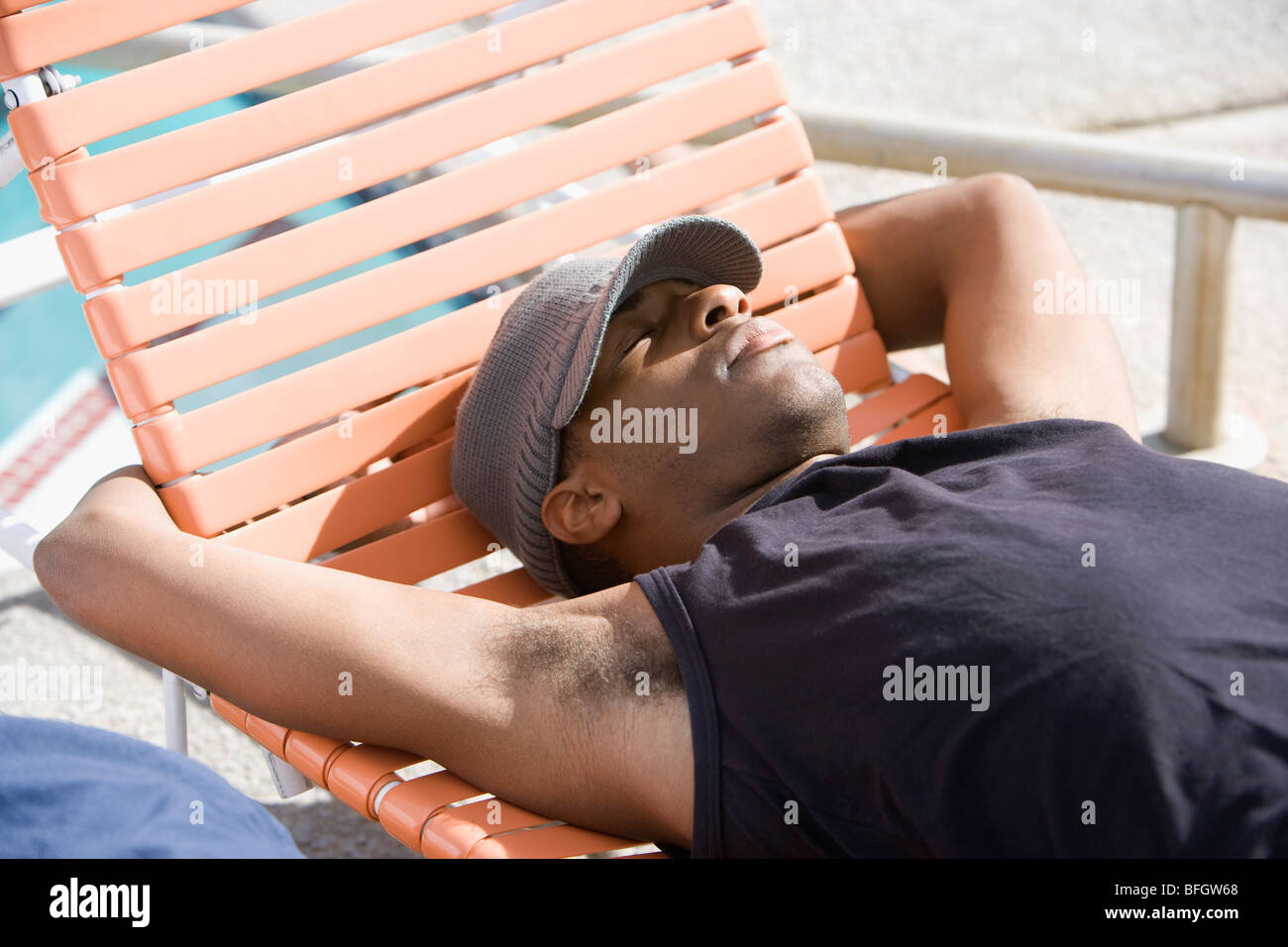 Young Man Relaxing by Swimming Pool Stock Photo - Alamy