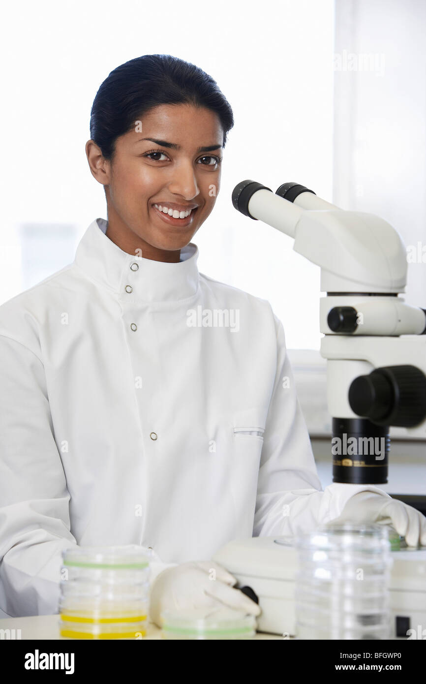 Female Asian lab worker standing by microscope Stock Photo - Alamy